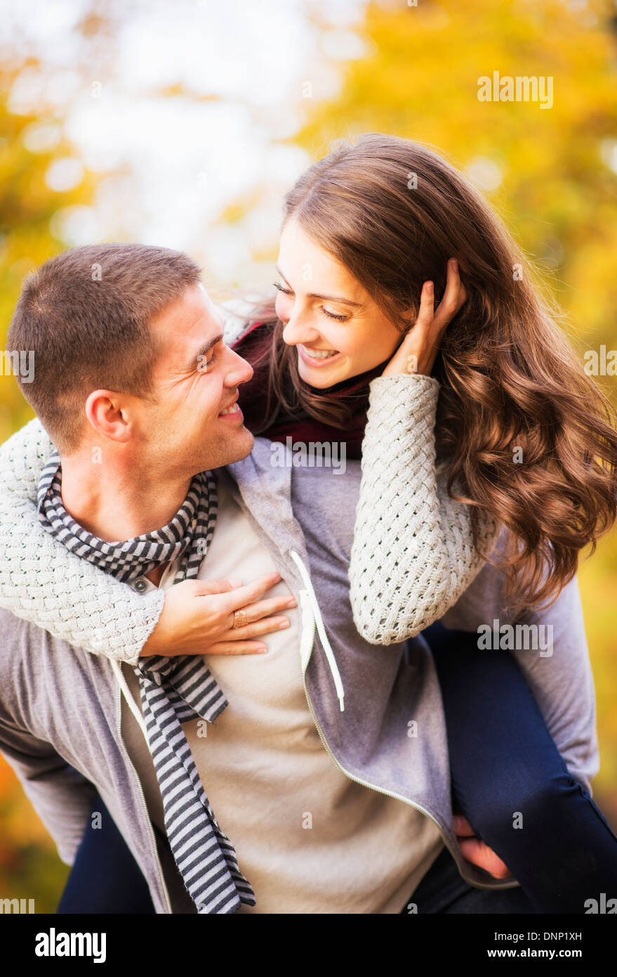 USA, New York City, Central Park, Man giving piggy back ride to woman ...