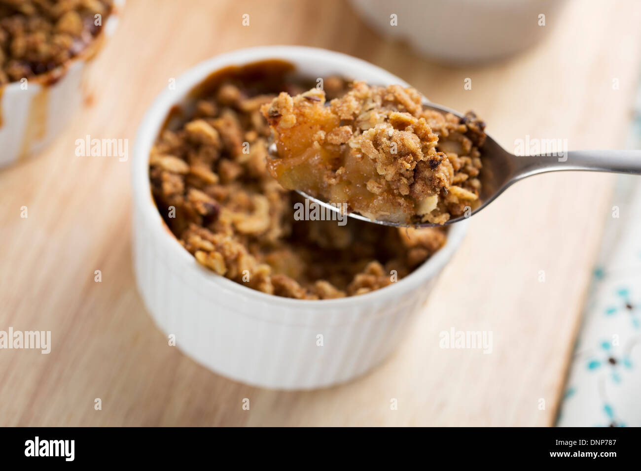 Spoon full of fresh apple crumble from single serving Stock Photo - Alamy