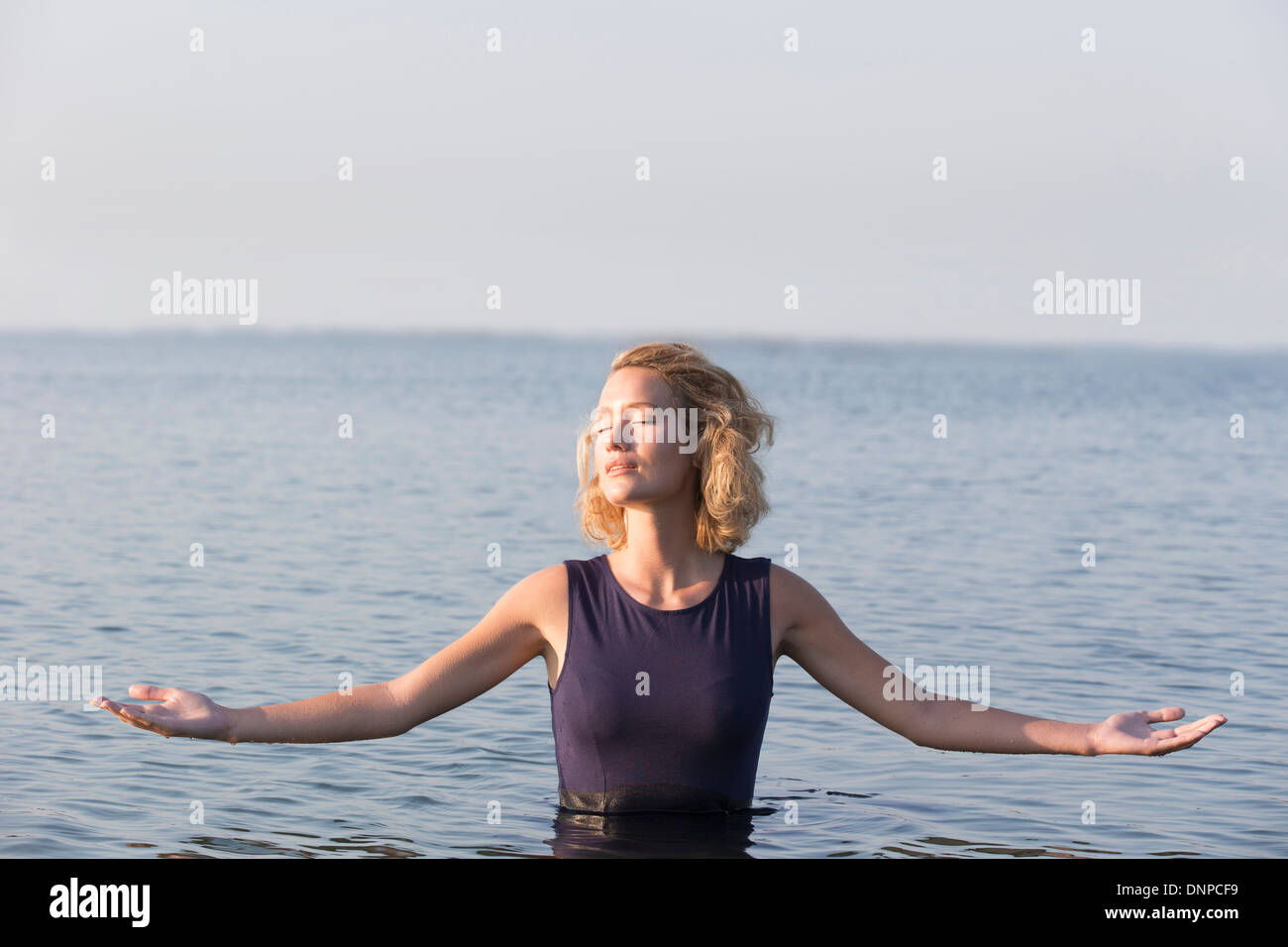 Beautiful woman standing in lake with arms outstretched Stock Photo - Alamy