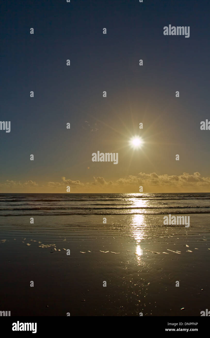 Sun setting over a peaceful beach Stock Photo - Alamy