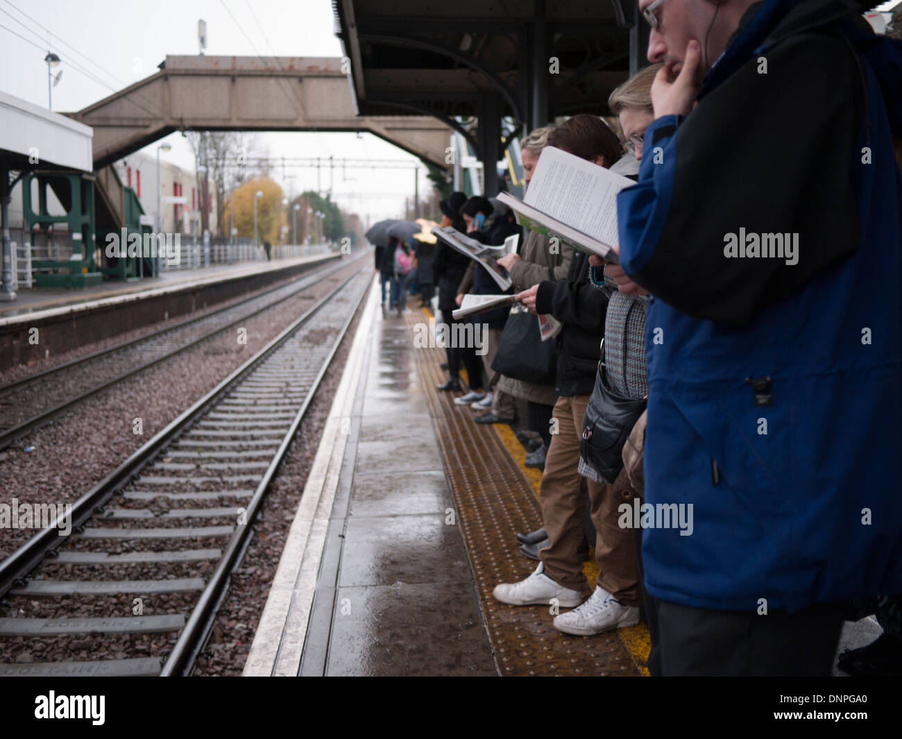 commuters in London waiting for train while reading books and ...