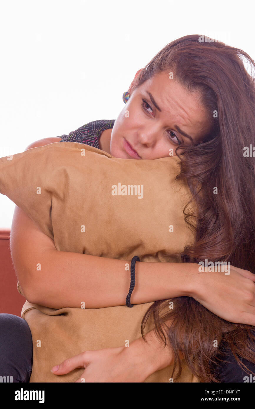 cute sad girl sitting and hugging pillow Stock Photo - Alamy