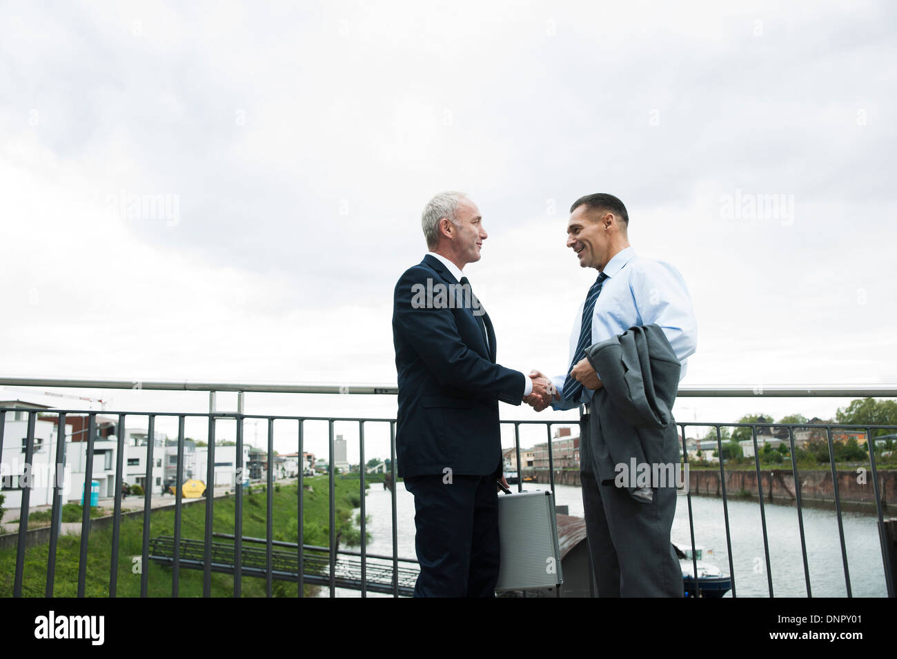 Standing shaking hands smiling river water hi-res stock photography and ...