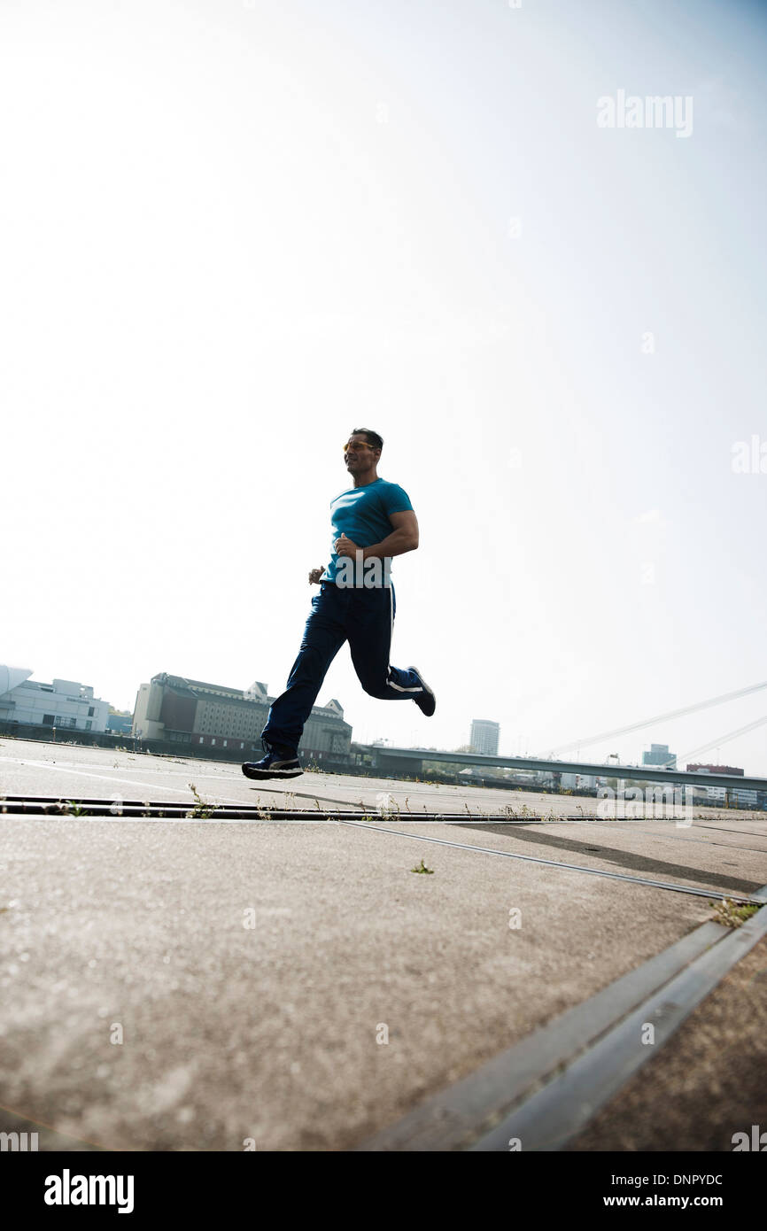 Mature man running along loading dock, Mannheim, Germany Stock Photo ...