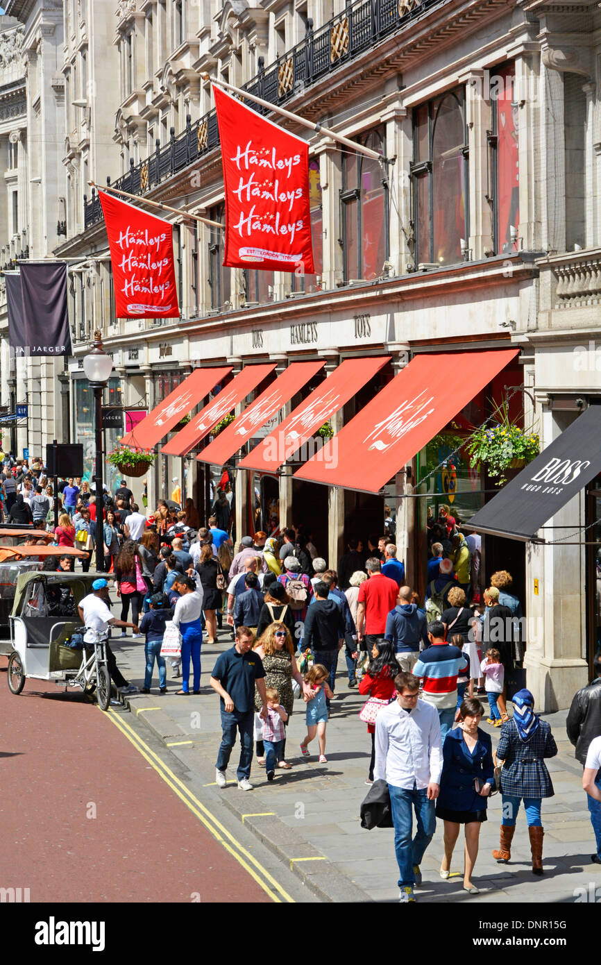 Busy pavement red banners at famous Hamleys toy shop business Regent ...