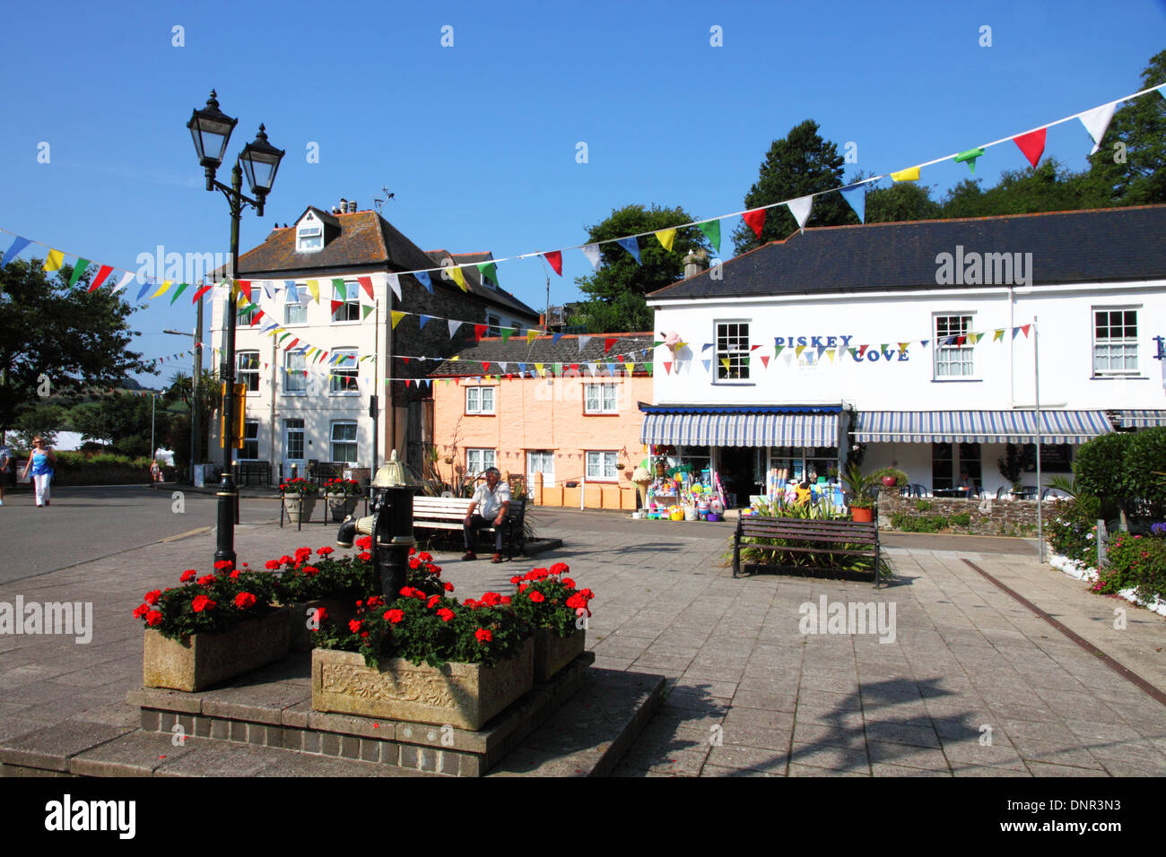 A village square with flowers, a pump and lamp post Stock Photo - Alamy