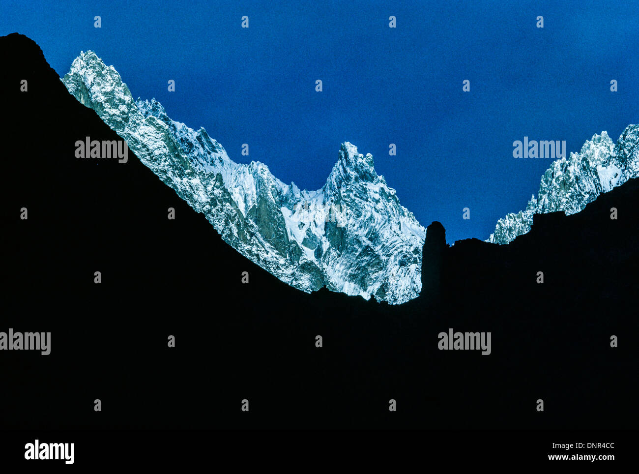 Vast mountain scape with dark shadow and bright snow and ice capped ...