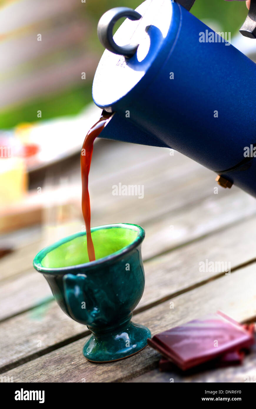 Pouring espresso coffee from classic blue coffee pot / Morning coffee ...
