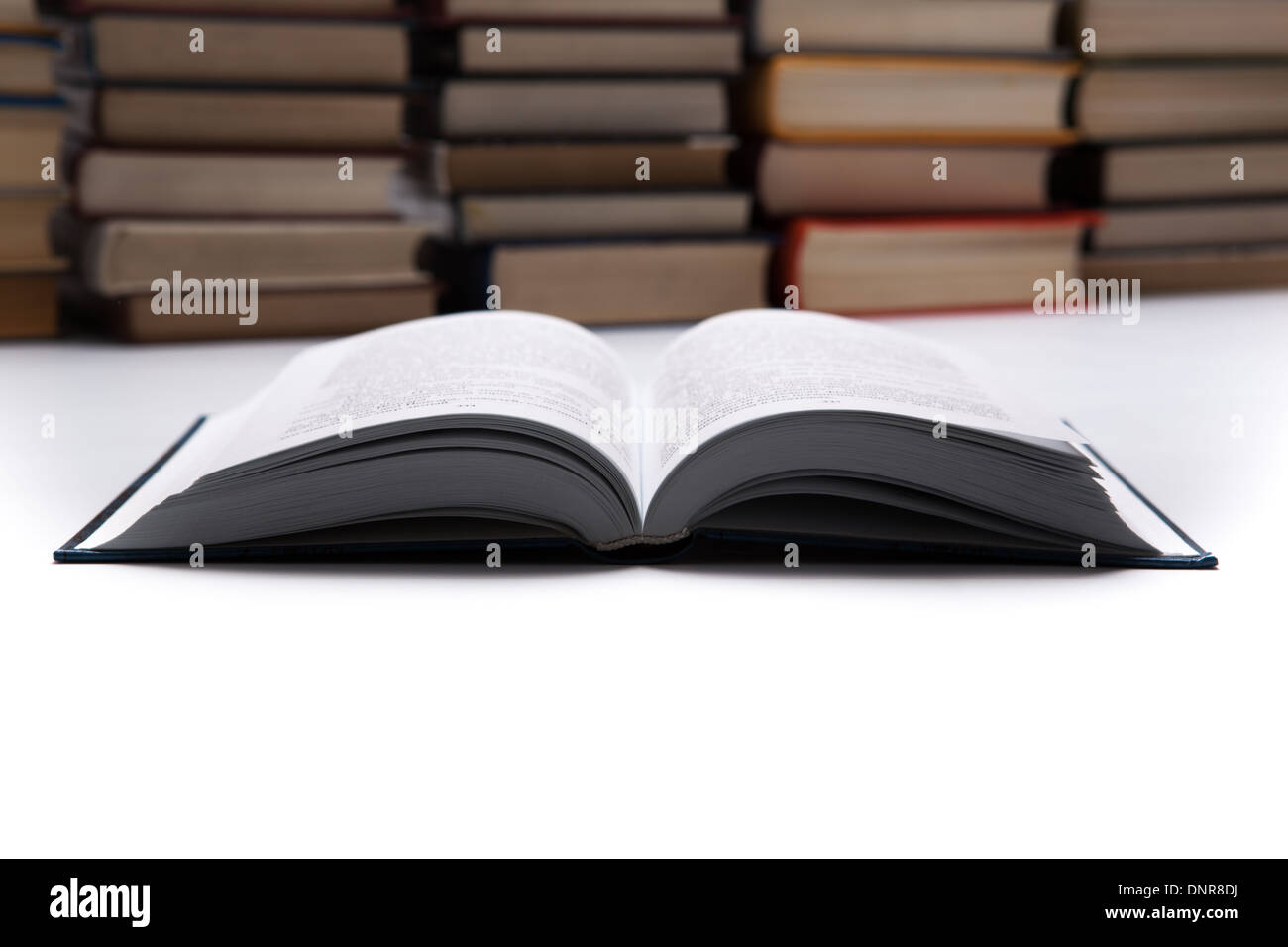 open book on with pile of books close up Stock Photo - Alamy