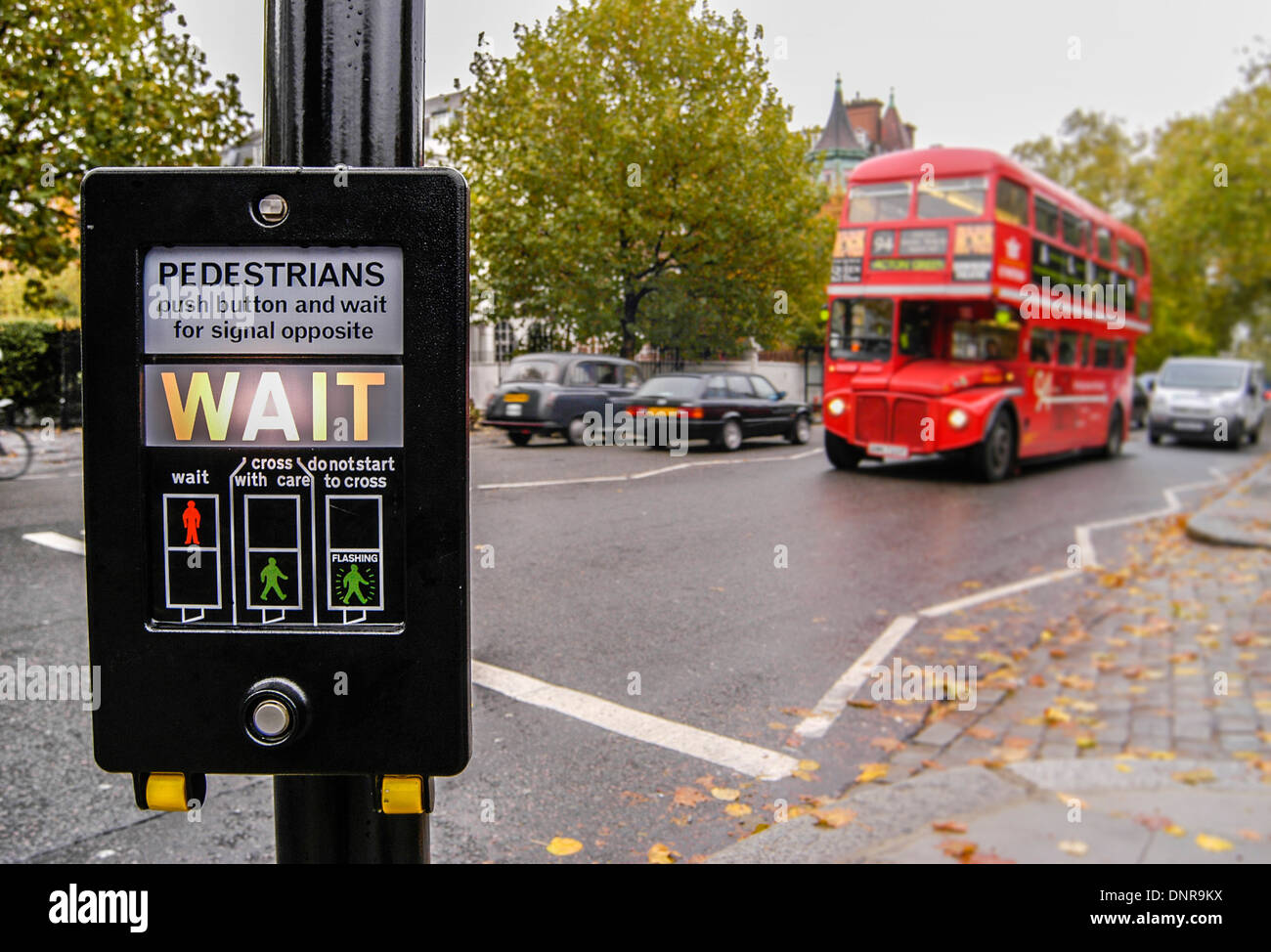 Pedestrian crossing WAIT sign with red London Bus Stock Photo - Alamy