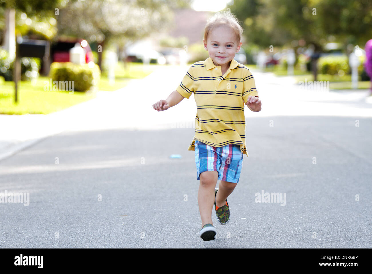 Boy running in the street Stock Photo - Alamy