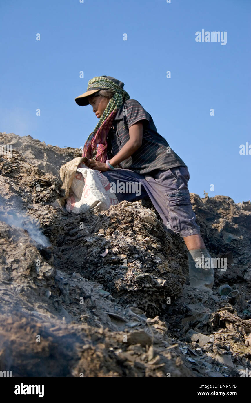 A young child laborer girl is collecting recyclable material at the ...
