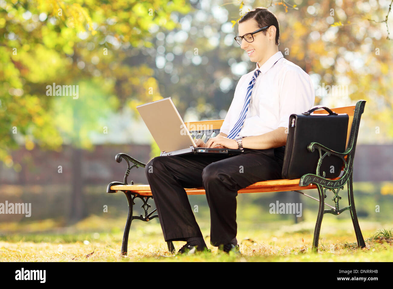 Man sitting on a park bench with a laptop hi-res stock photography and ...