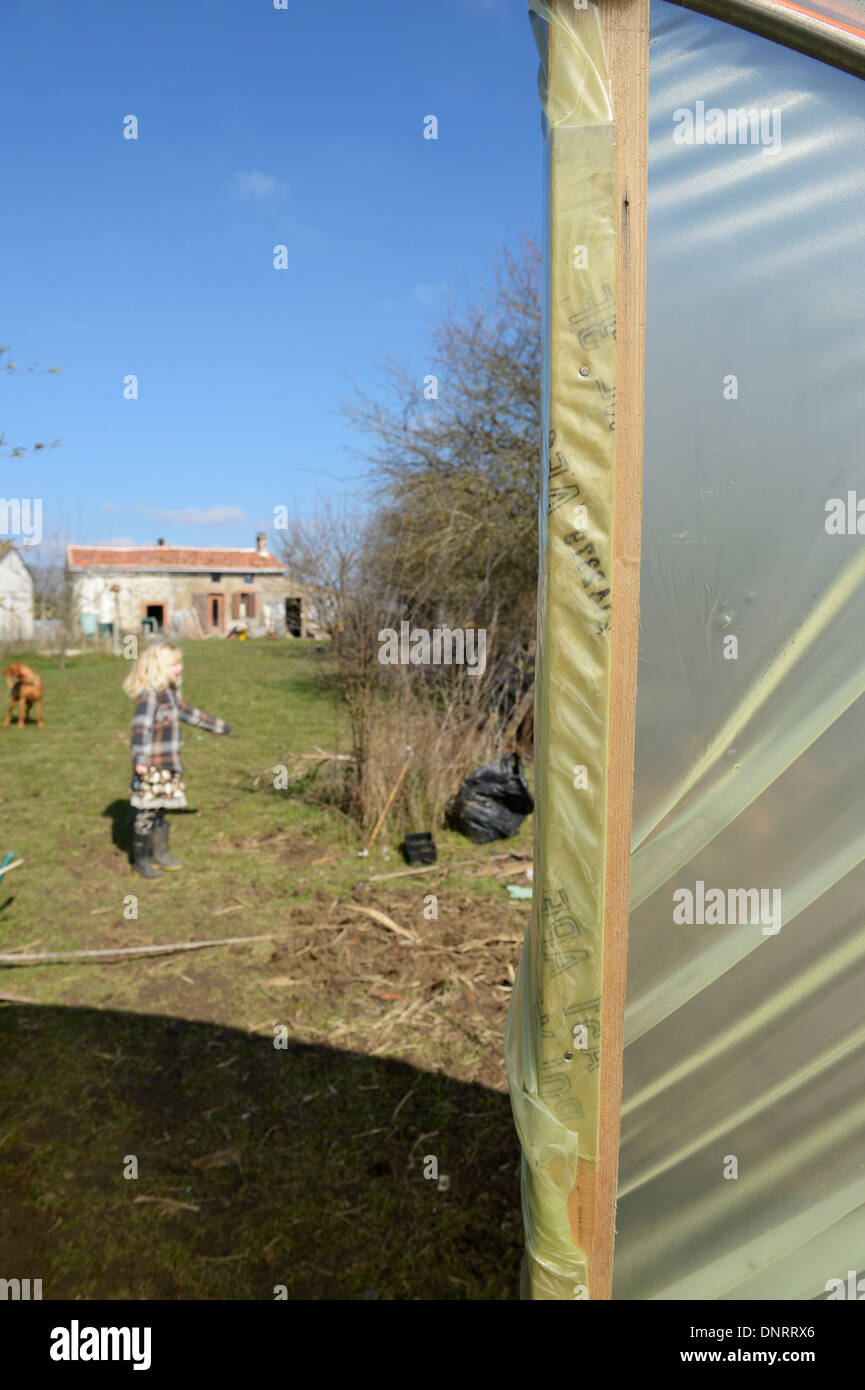 New plastic sheet being fitted to a polytunnel frame Stock Photo - Alamy