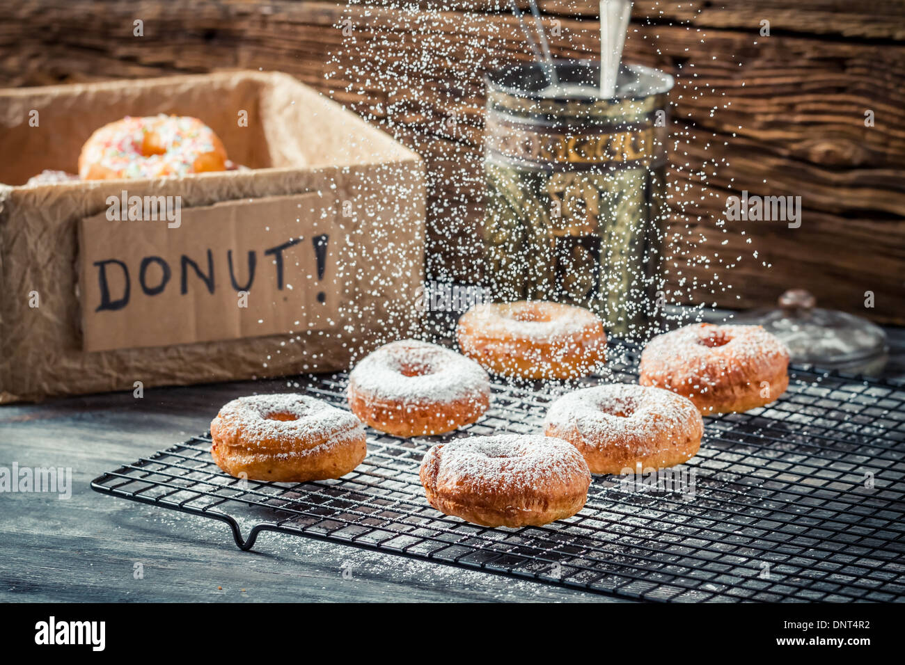 Icing sugar falling on fresh donuts Stock Photo - Alamy