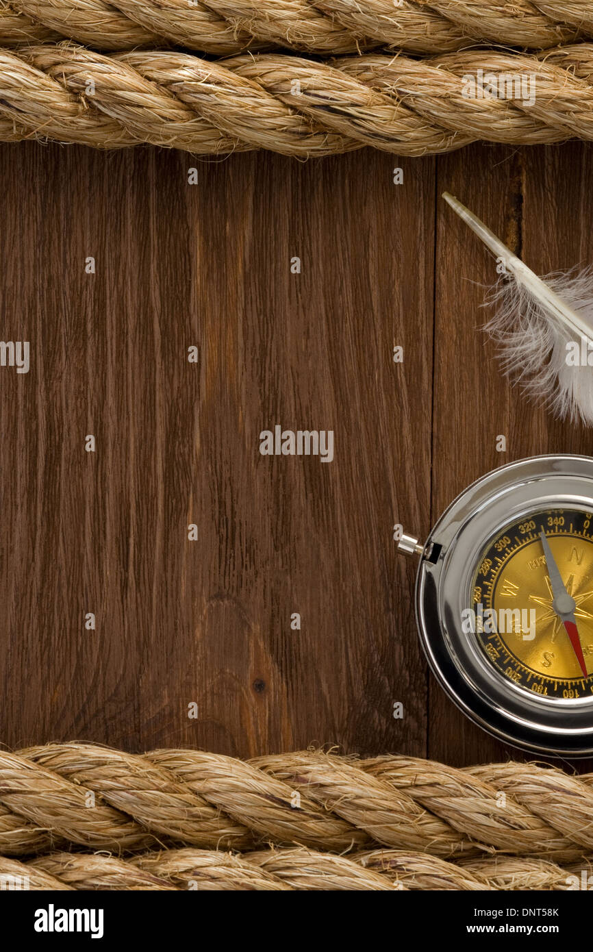 ship ropes and compass with feather at old wooden background Stock ...
