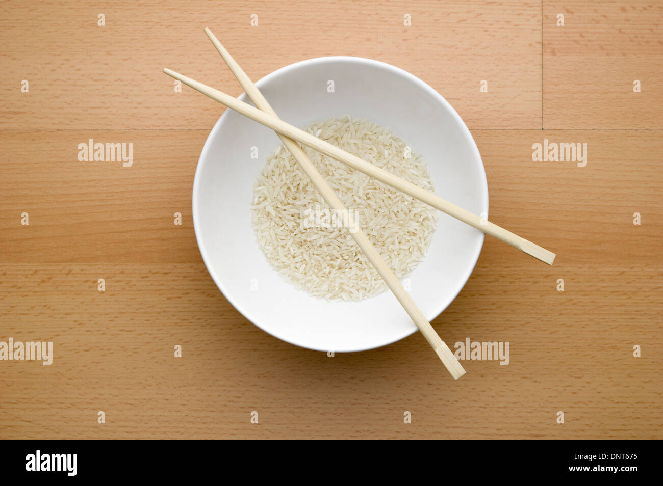 Half full bowl of rice with chop-sticks Stock Photo - Alamy