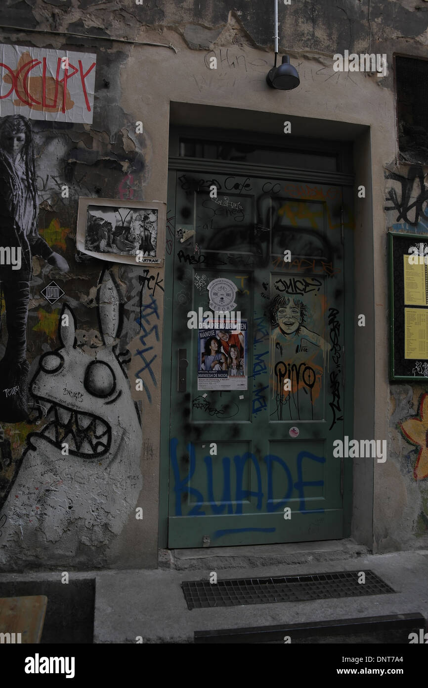 Courtyard building green door, graffiti scrawl, 'Knut' crazy bear head ...