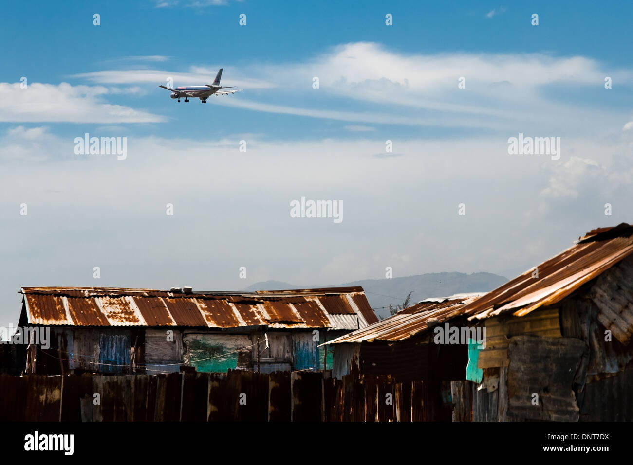 An airplane flies over the shacks of the slum of Cité Soleil, Port-au ...