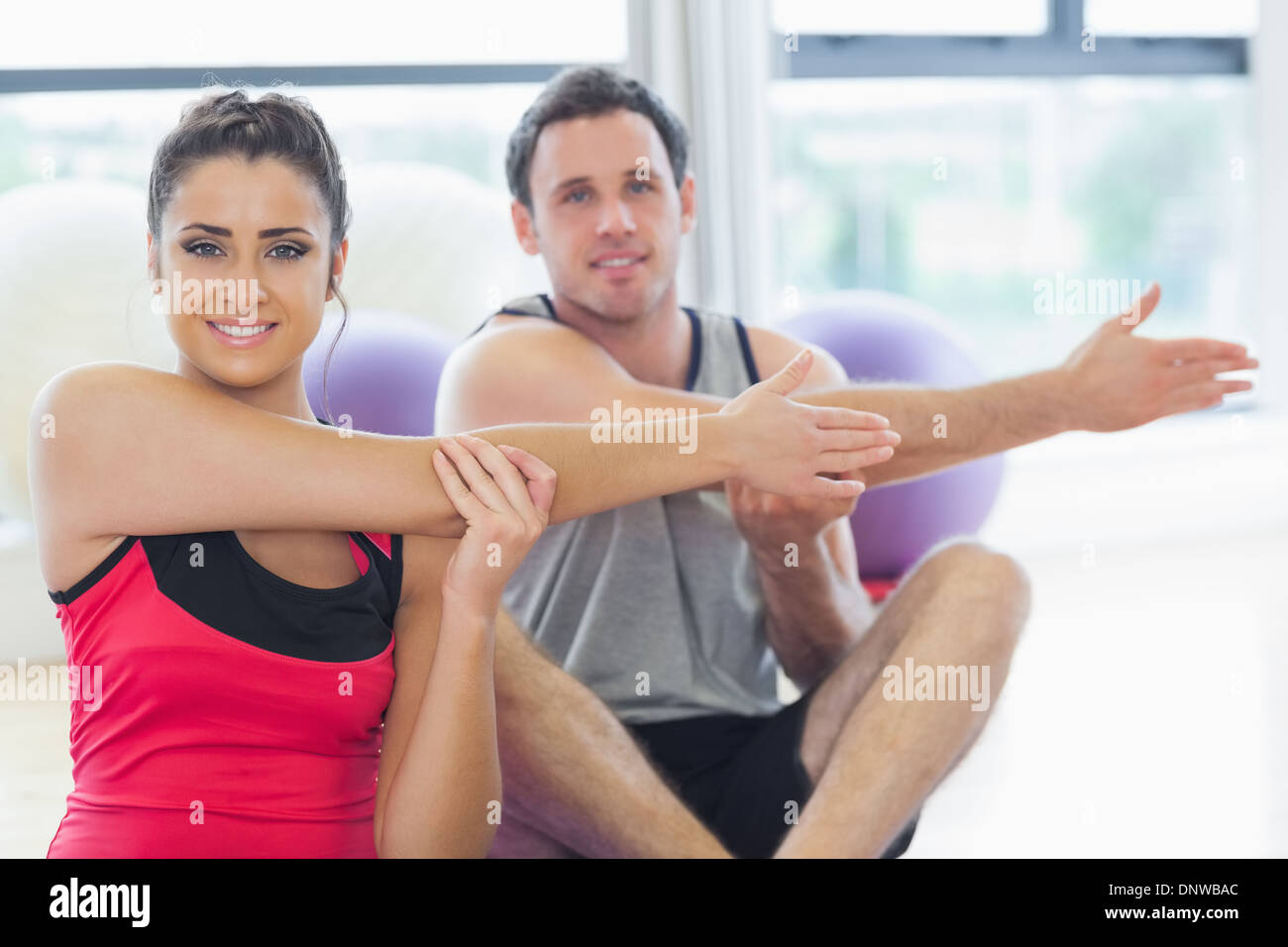Two sporty people stretching hands at yoga class Stock Photo - Alamy