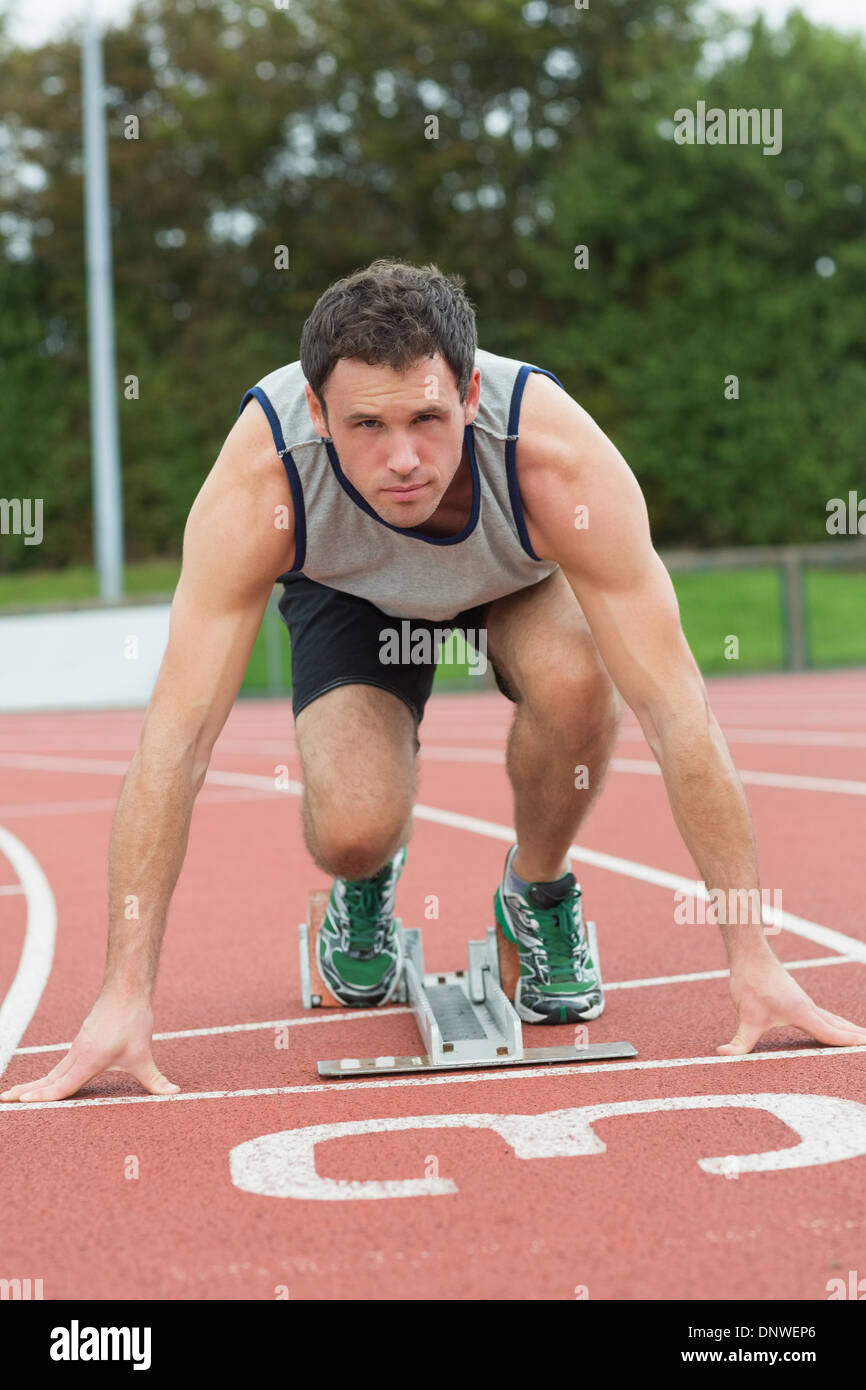 Young man ready to race on running track Stock Photo - Alamy