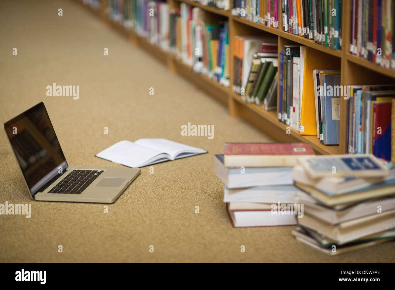Laptop and books on the library floor Stock Photo - Alamy