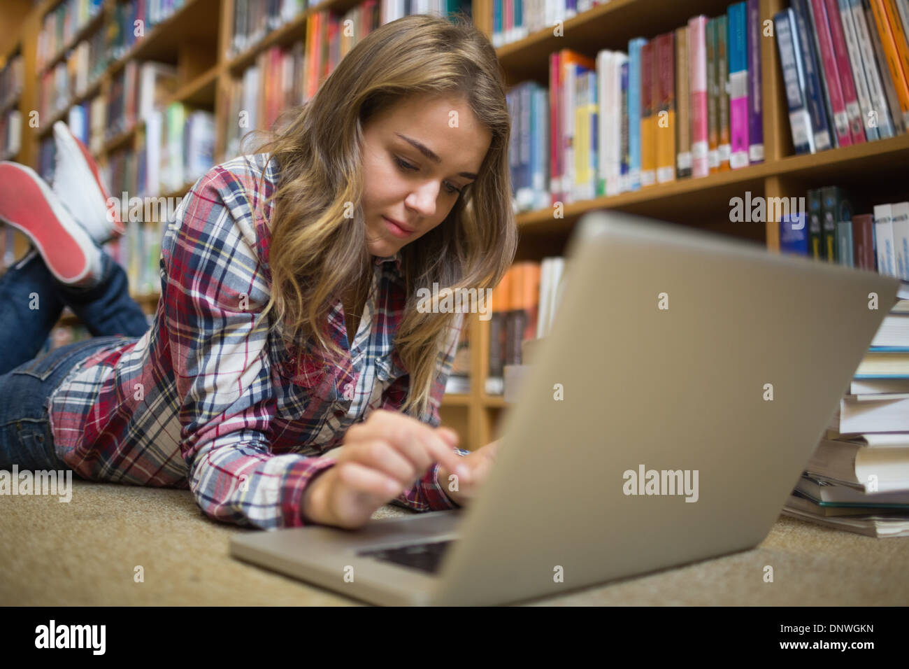 Young happy student lying on library floor using laptop Stock Photo - Alamy