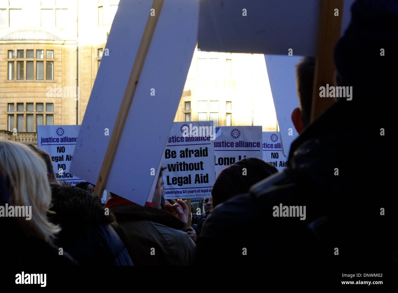 London, UK. 06th Jan, 2013. Crowds hold banners to protest cuts to ...