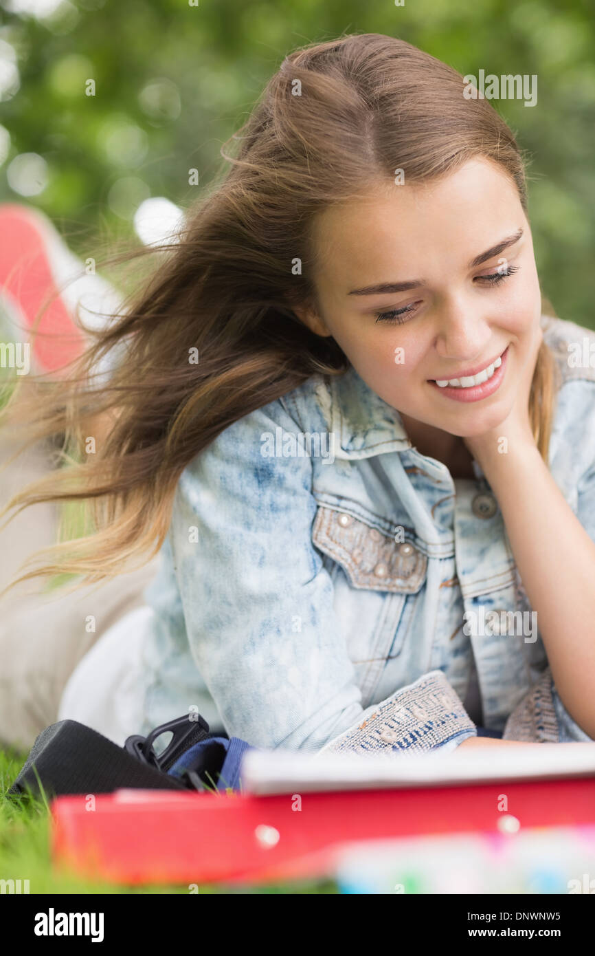 Smiling young student studying on grass Stock Photo - Alamy
