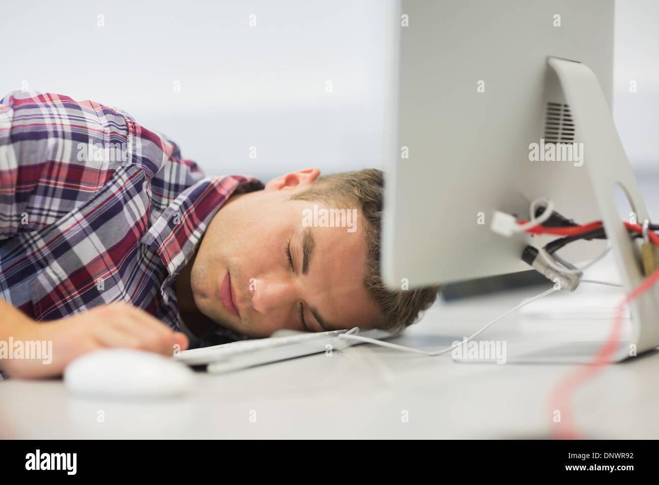 Handsome student dozing in the computer room Stock Photo - Alamy