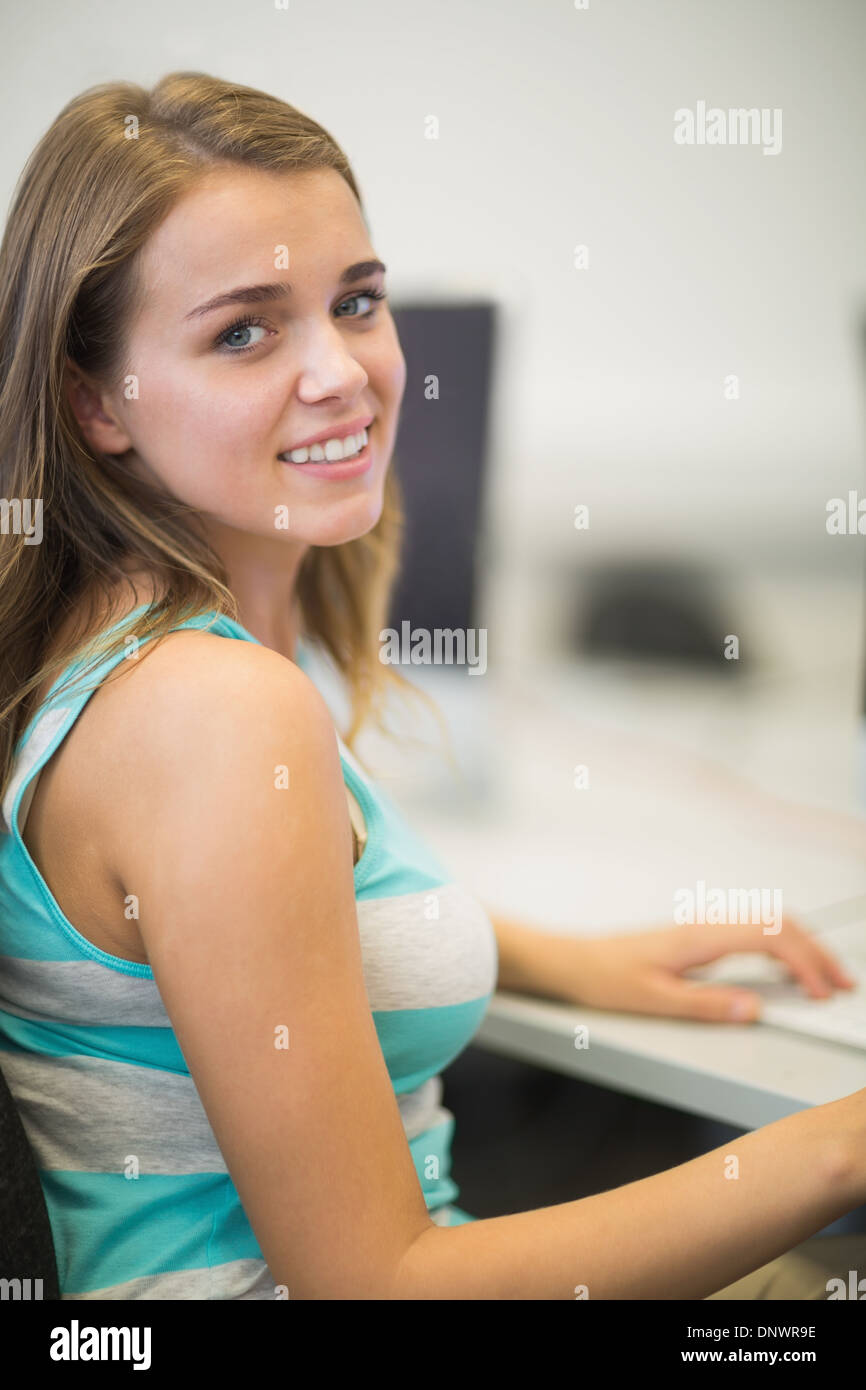 Happy student smiling at camera in the computer room Stock Photo - Alamy