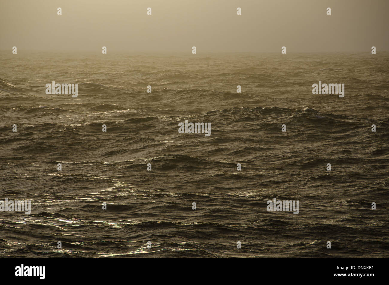 A passing rain squall captures the dusk light on relatively calm waters ...