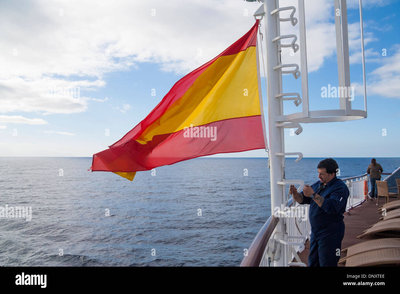 Crew member of Canary Islands ferry raising Spanish flag as ferry ...