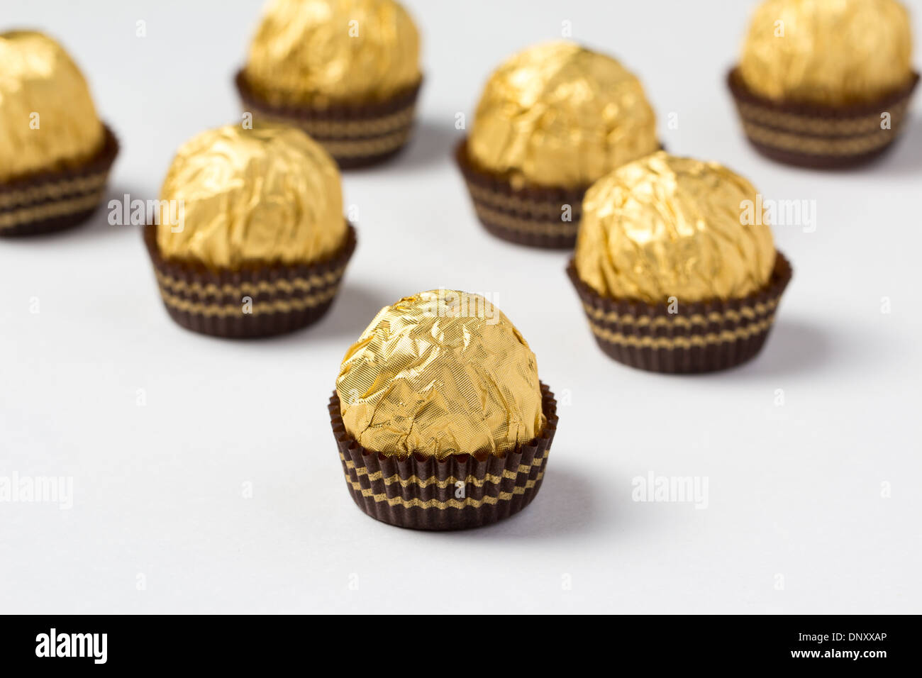 Group of chocolate candies wrapped in golden foil Stock Photo - Alamy