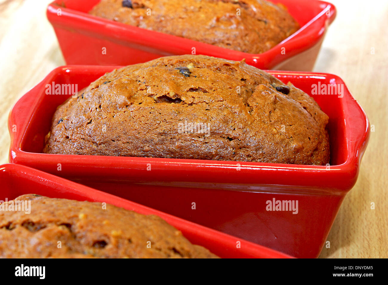 pumpkin chocolate chip bread in red loaf pans cooling on a kitchen ...