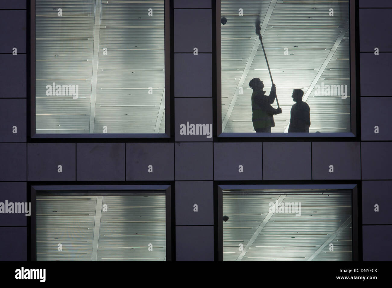 A workman wipes the ceiling of a vacant office building in the City of ...