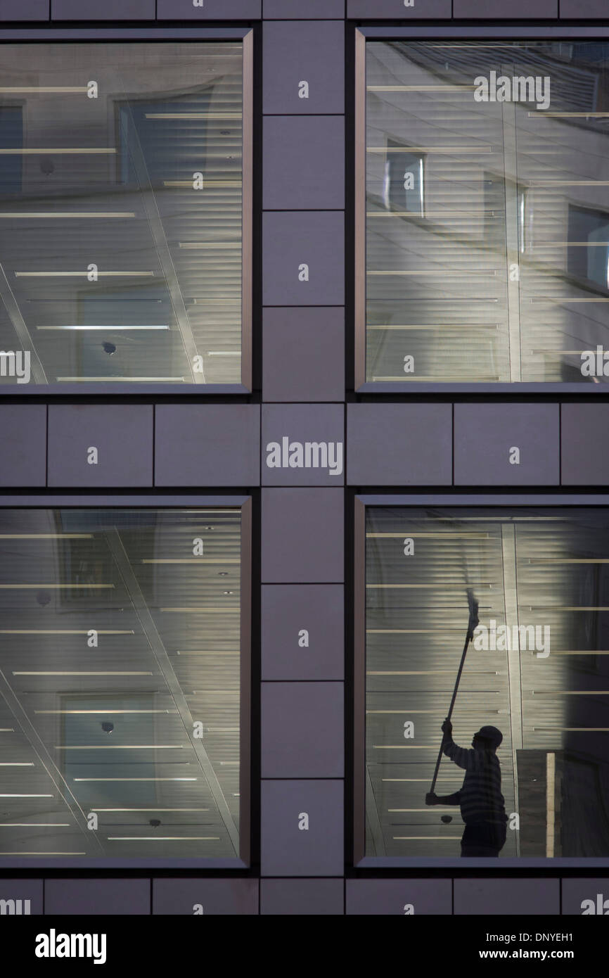 A workman wipes the ceiling of a vacant office building in the City of ...
