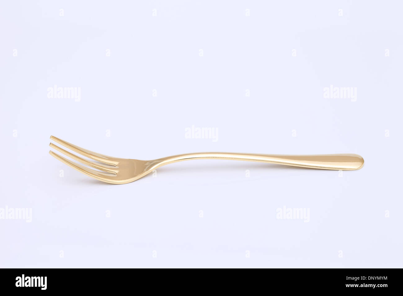 golden fork on white background Stock Photo - Alamy