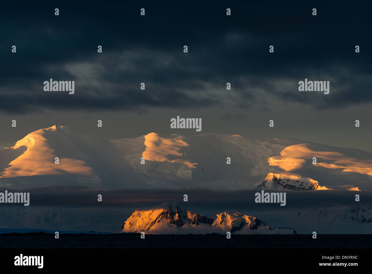 ANTARCTICA - The setting sun, very low on the horizon, catches steep ...