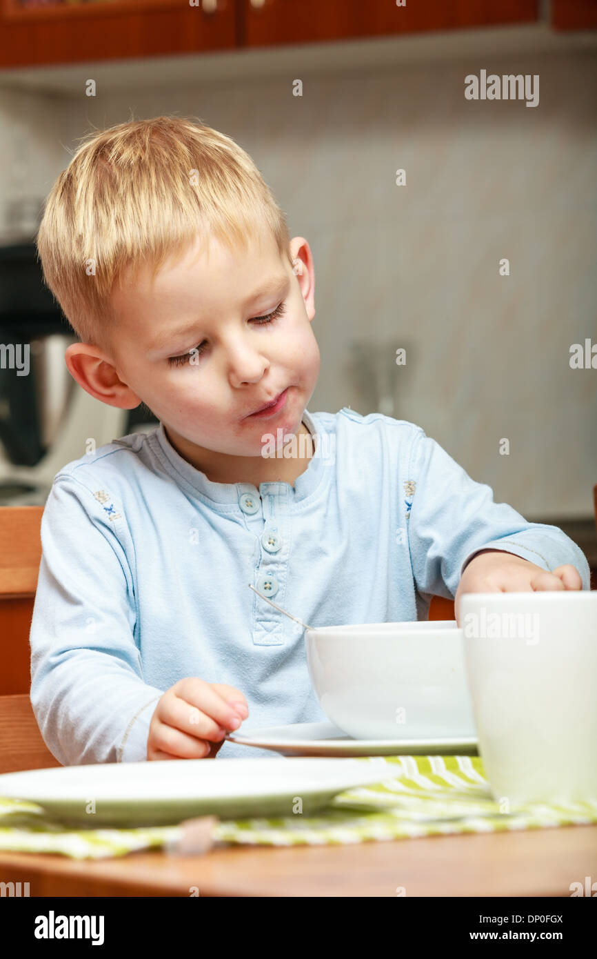 Blond boy kid child eating corn flakes breakfast morning meal at the ...