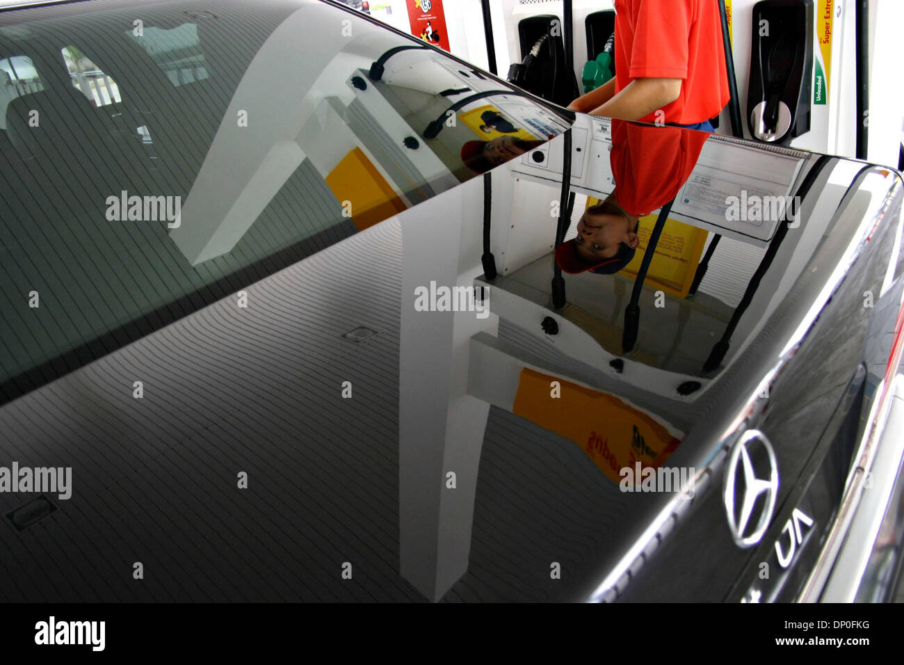 Mar 17, 2006; Jakarta, INDONESIA; Reflection of petrol station officer ...