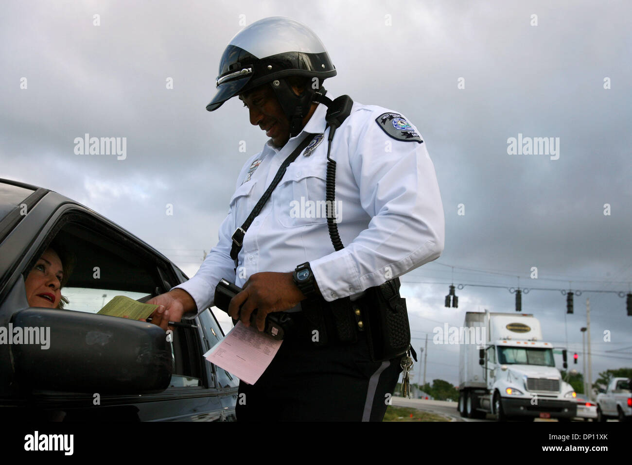 A Police Officer Giving Ticket At A Intersection