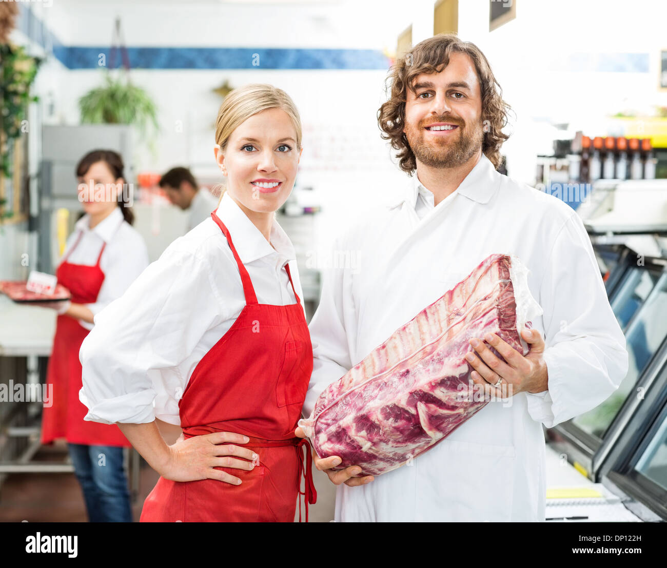 Confident Butchers With Meat Package Stock Photo - Alamy