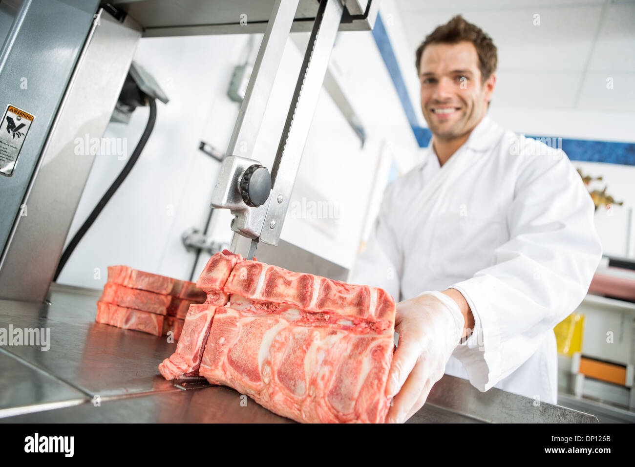 Male Butcher Cutting Meat On Bandsaw Stock Photo - Alamy