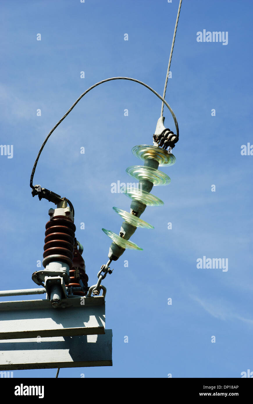 Insulators on a high voltage electric pillar jn the blue sky background ...