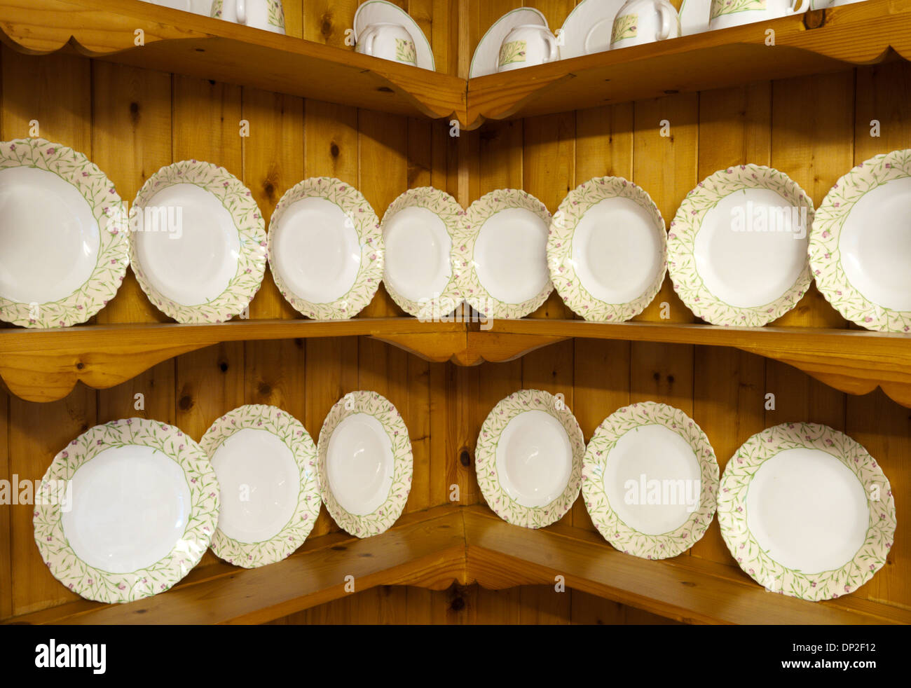 Plates stood on edge on corner shelves in a country kitchen Stock Photo ...