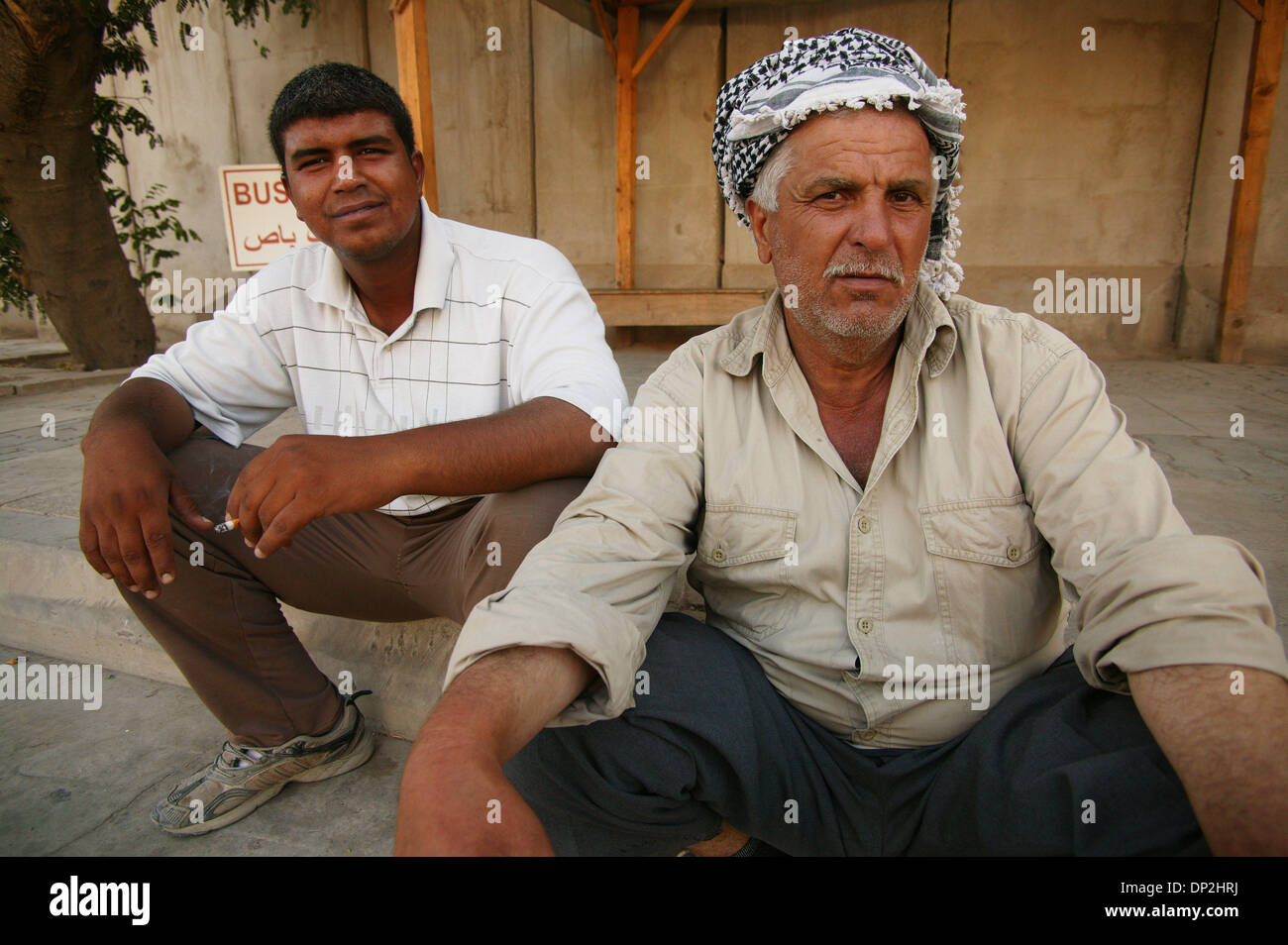 Jun 05, 2006; Baghdad, IRAQ; Iraqi men wait at a bus stop in Baghdad's ...