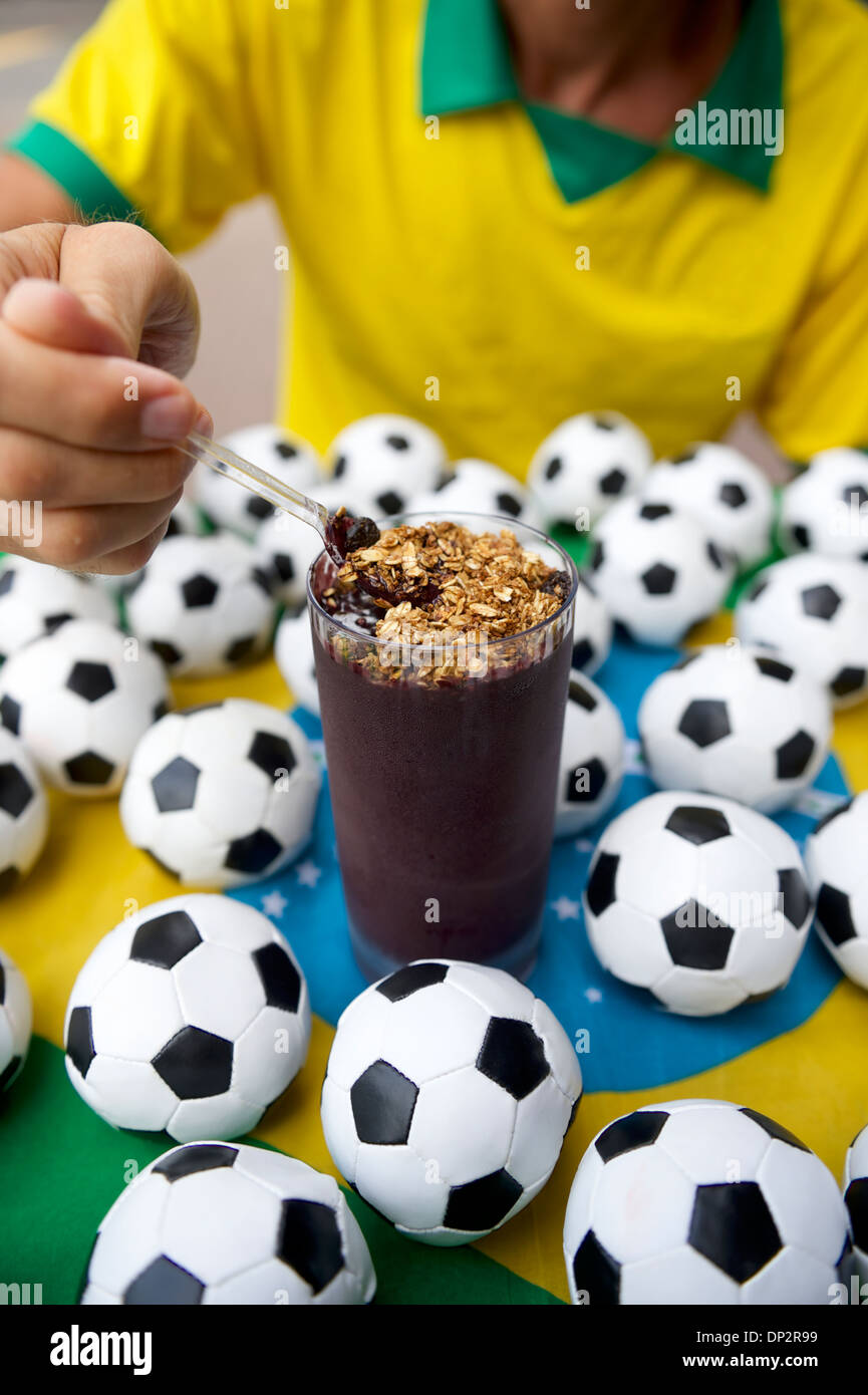 Brazilian soccer player sits eating acai with granola in a glass ...