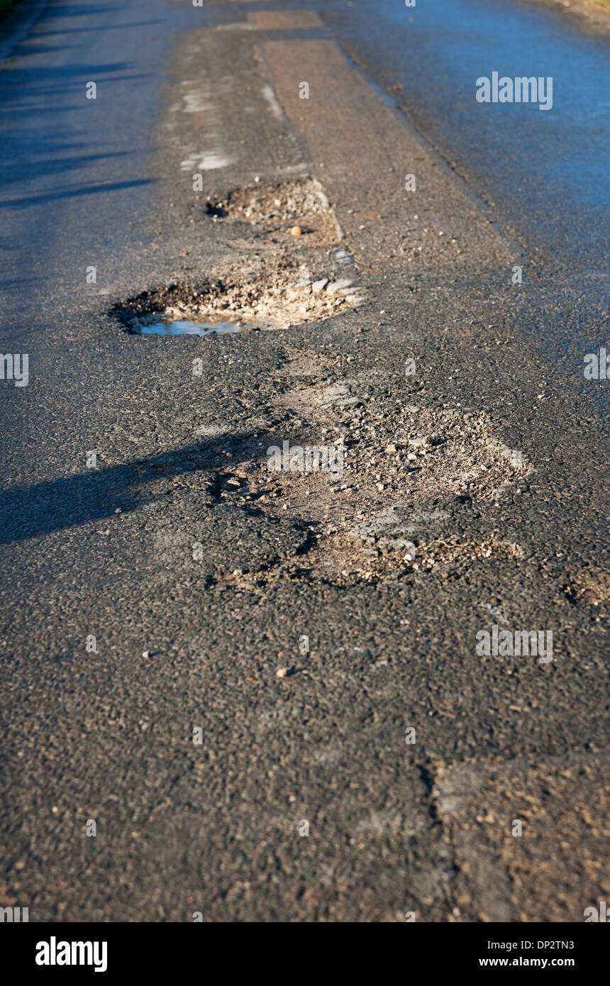 Close up of pothole potholes in the street road in winter England UK ...