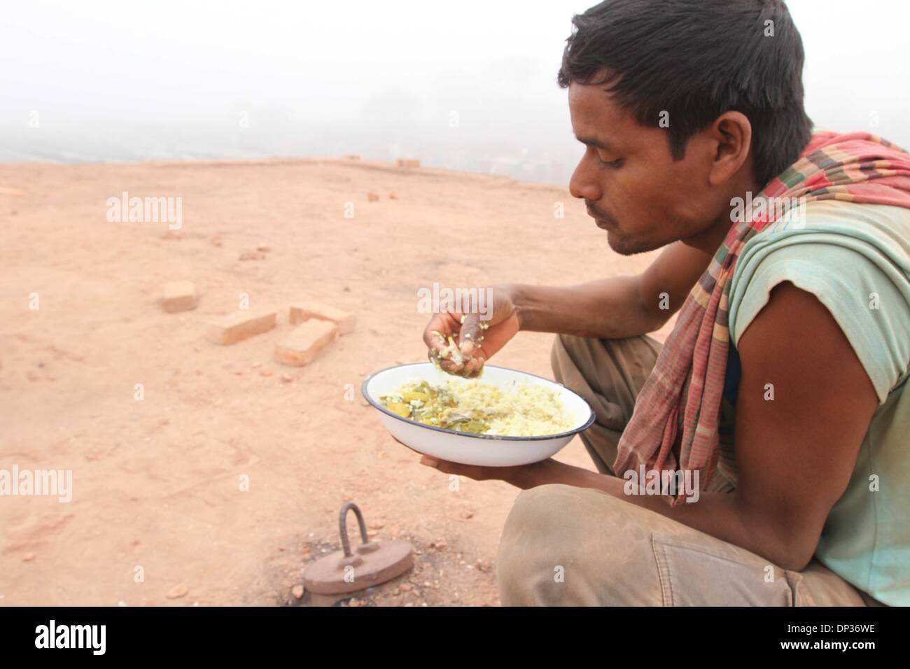 A laborer eats rice in brickfield at Savar, Dhaka 07 Jan 2014. Most of ...